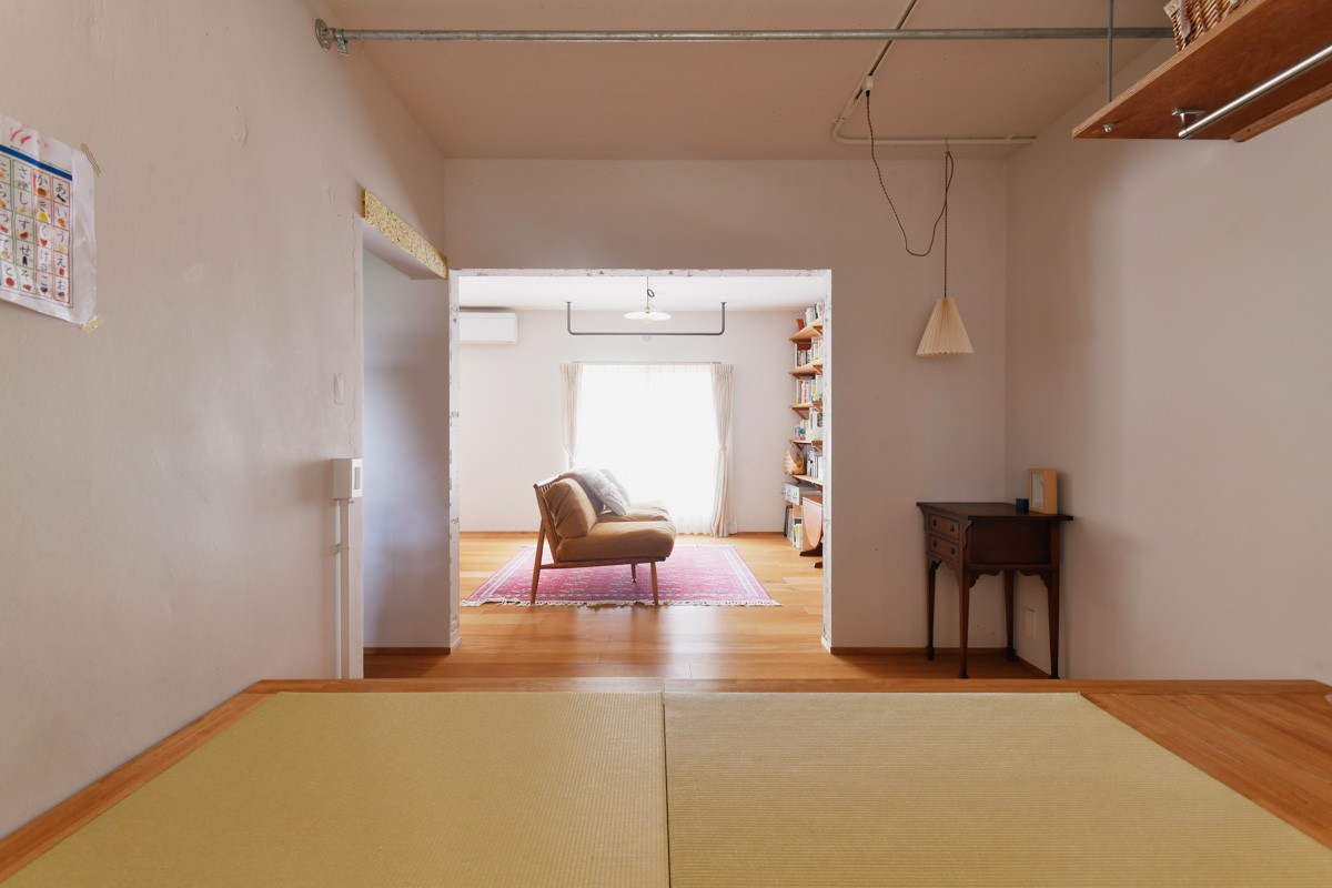 庭をとりこむLDKには壁一面の造作の本棚を。木の温もりを感じるアトリエと小上がりのある住まい - マンションリノベーション事例｜SUVACO(スバコ)